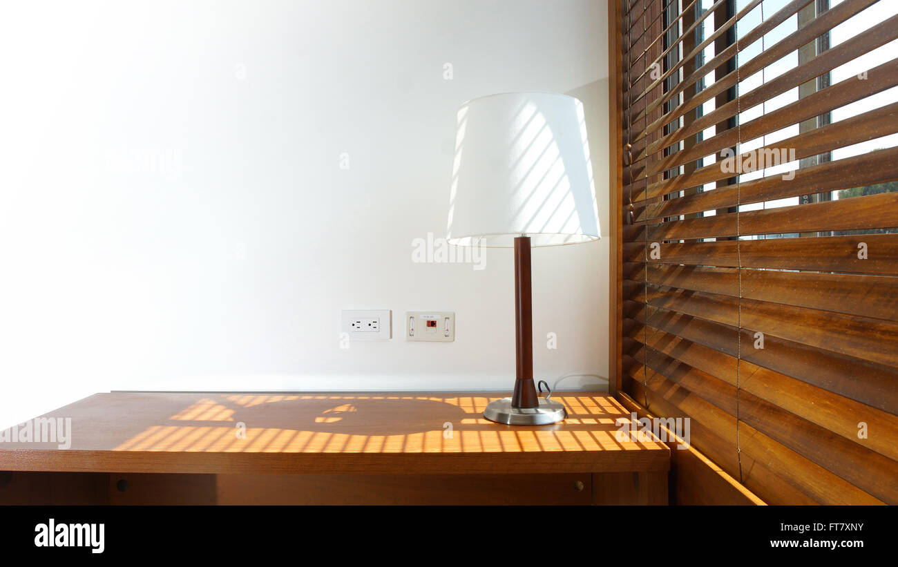 Wooden table with lamp with wooden shutters in a hotel room Wooden ...