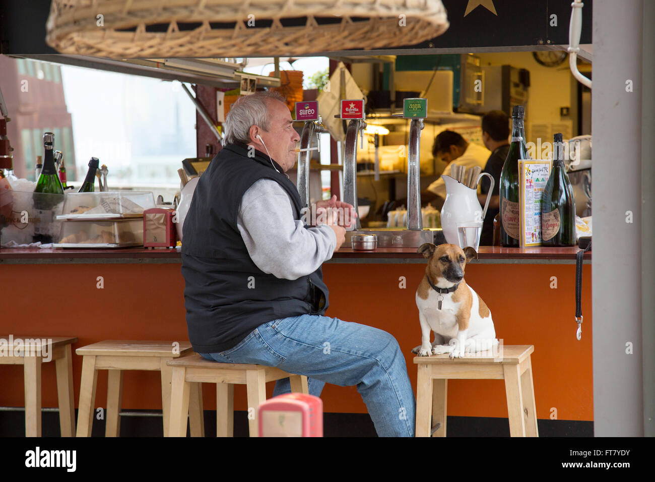 Man and dog sitting at bar on the beach in Barcelona, Spain. W Hotel in ...