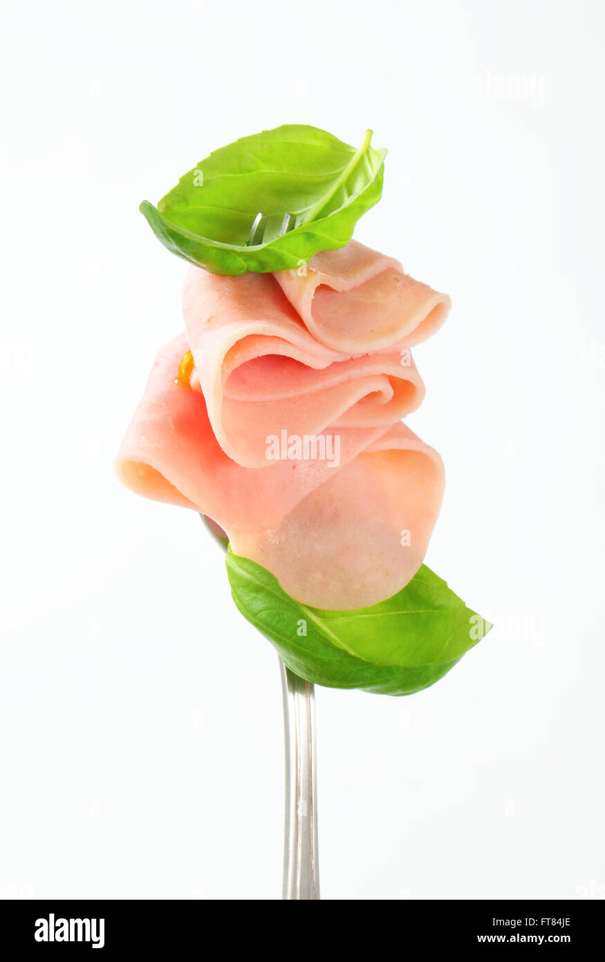 Thin slices of ham on fork Stock Photo - Alamy