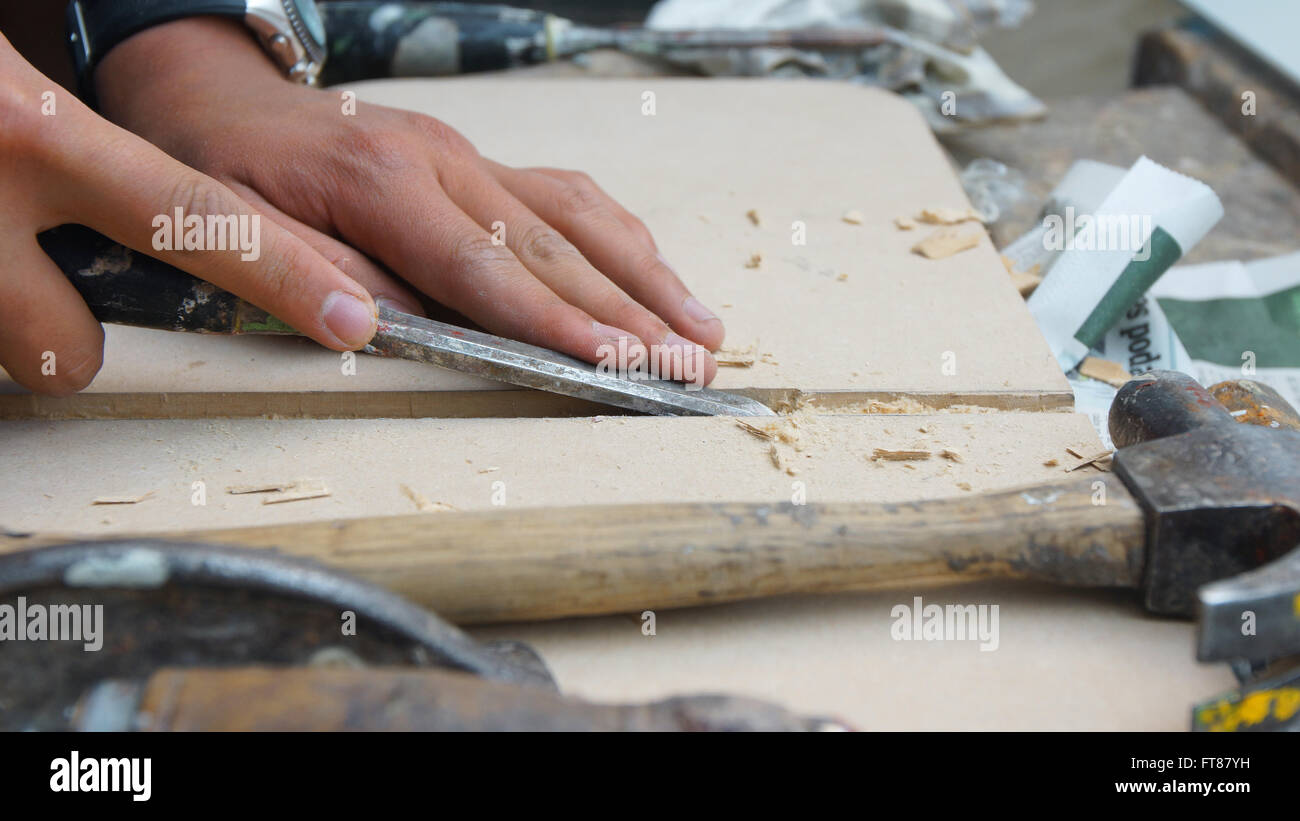 Hands holding a chisel carving a wooden board Stock Photo - Alamy