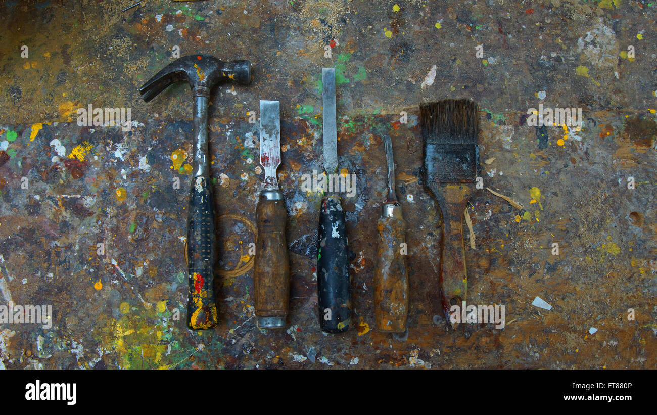 Old woodworking tools stained with paint on work table splattered with ...