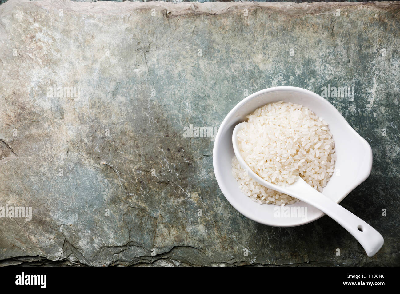 Raw white rice on gray stone slate background Stock Photo - Alamy