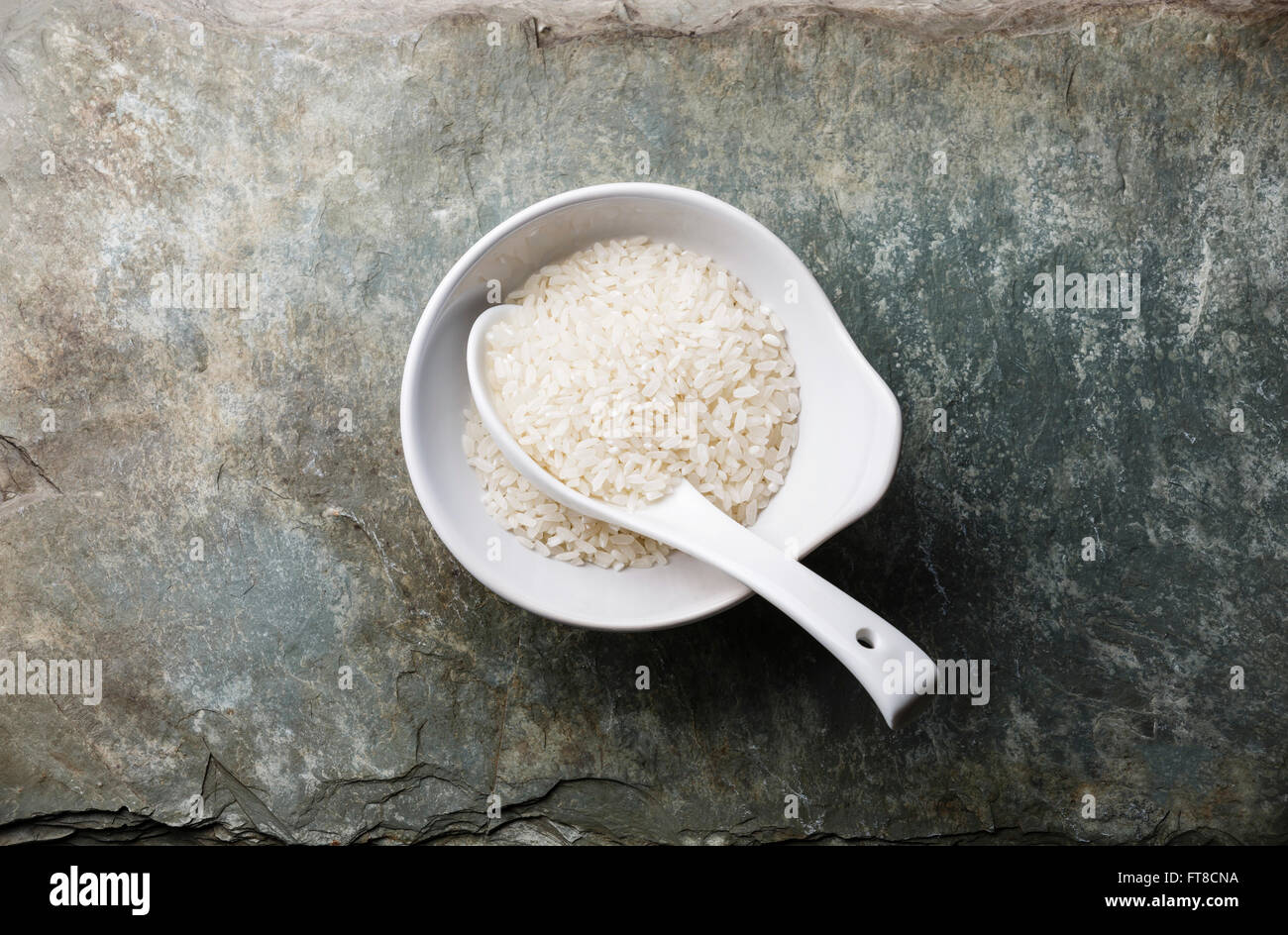 Raw white rice on gray stone slate background Stock Photo - Alamy
