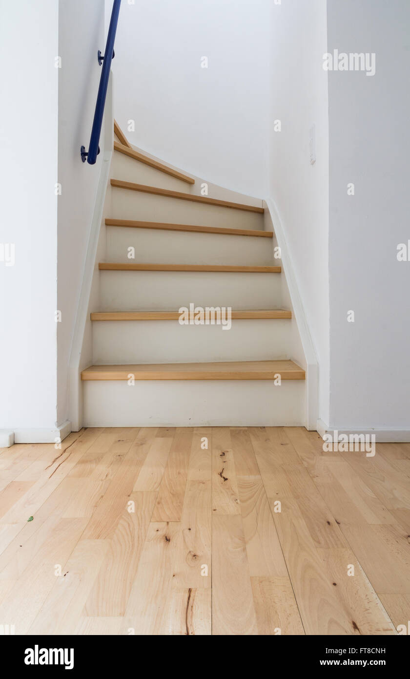 A closed stairway with steps made of light birch wood and risers ...