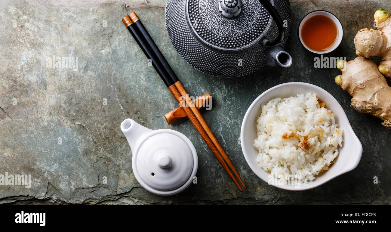 Steamed rice in bowl and green tea on stone slate background Stock ...