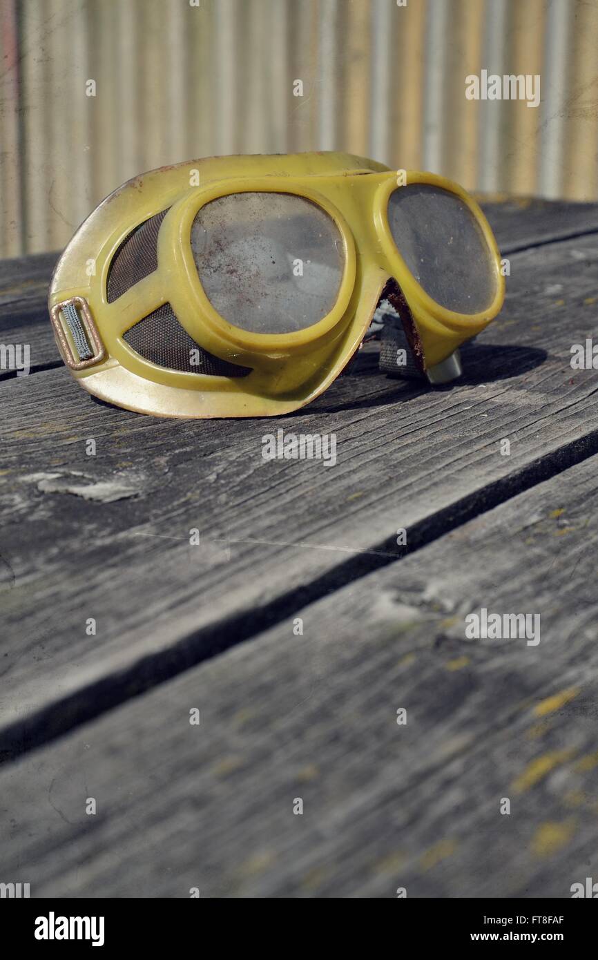 Yellow vintage safety glasses on a wooden table Stock Photo - Alamy