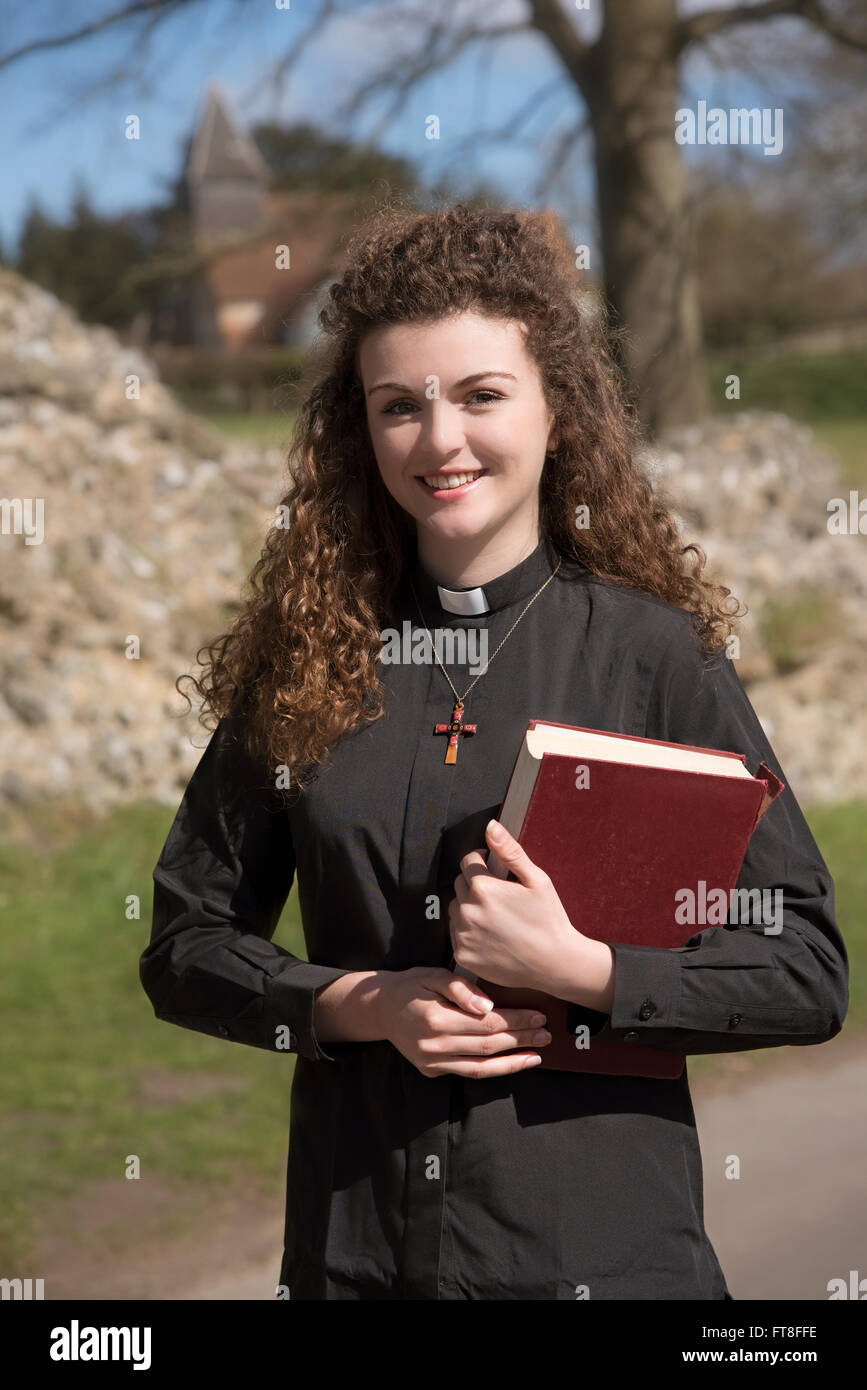 Young vicar walking around her country parish Stock Photo - Alamy