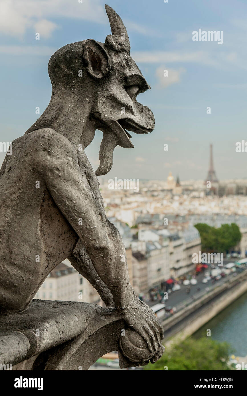 Gargoyle atop Notre Dame Cathedral and view of city (Eiffel Tower in ...