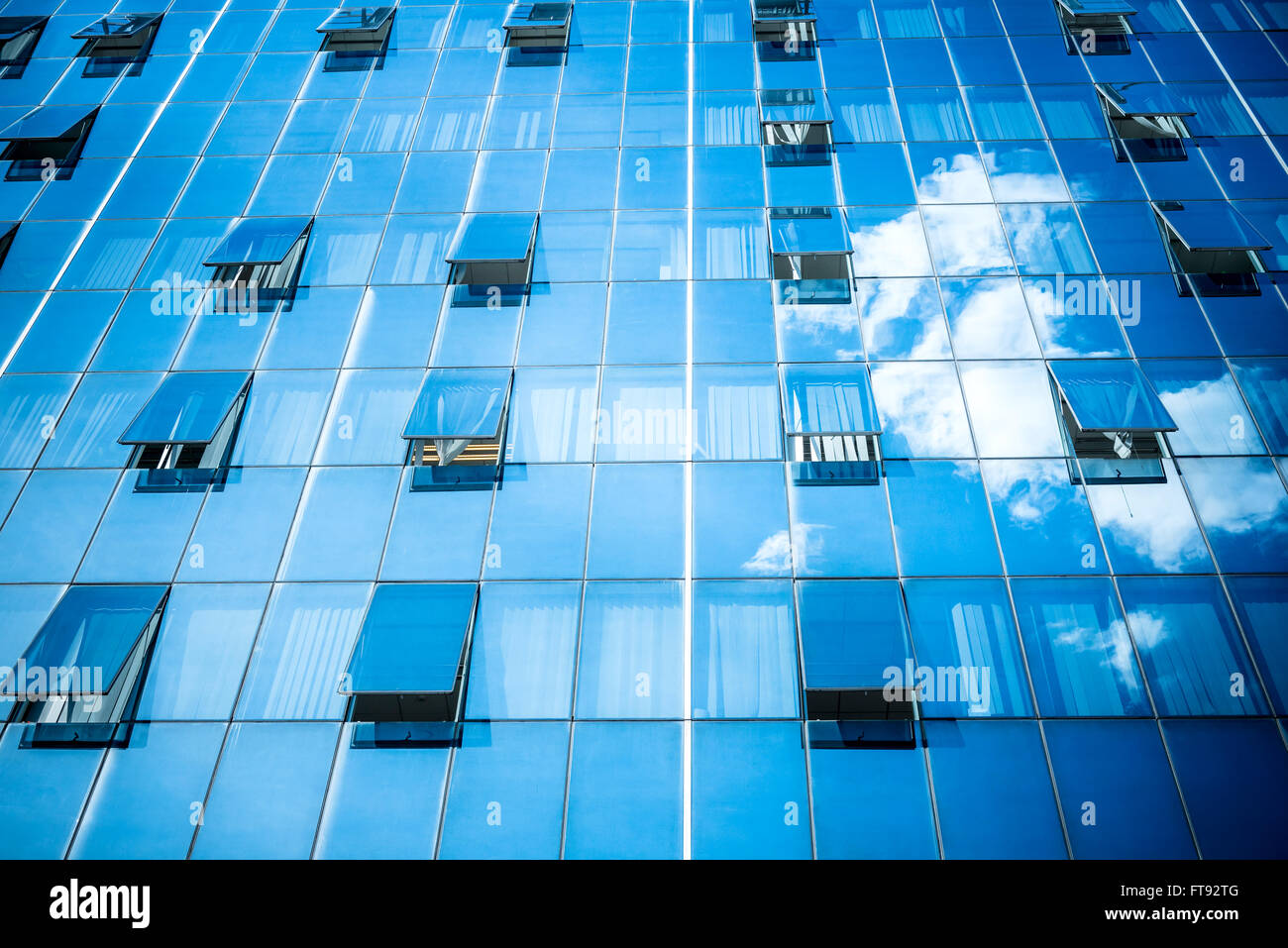 Building with open windows and clouds reflection Stock Photo - Alamy