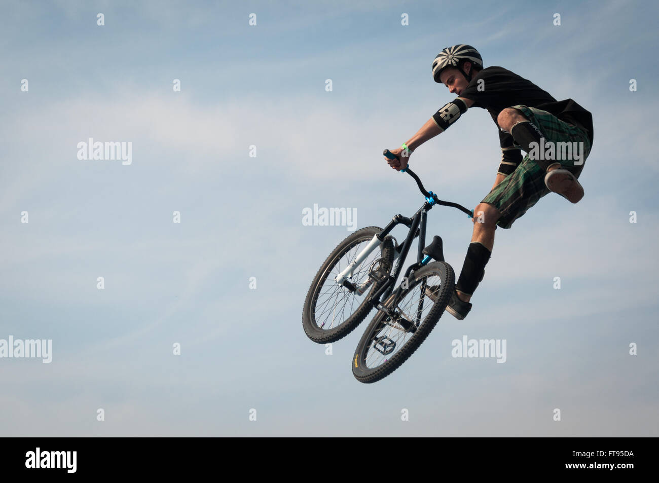 Biker with BMX bike jumping into the air performing dirt jumping Stock ...