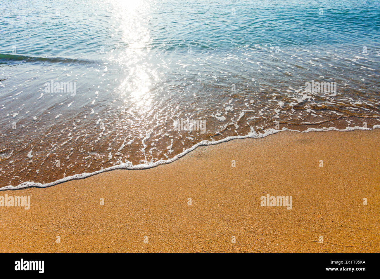 Sun light reflected on soft wave sea on the sandy beach Stock Photo - Alamy
