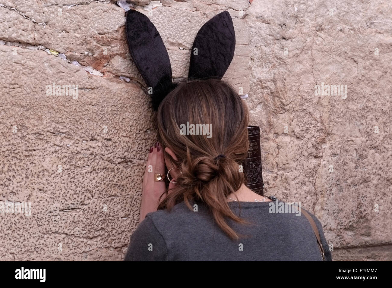 A religious Jewish woman wearing bunny ears costume praying during the ...