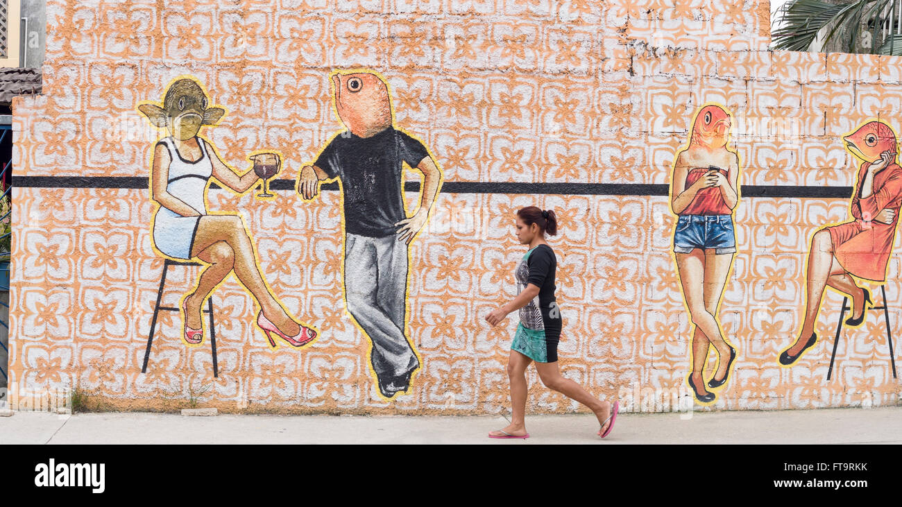 Fish Head Mural on a Tulum street. A woman walks by a large mural by ...