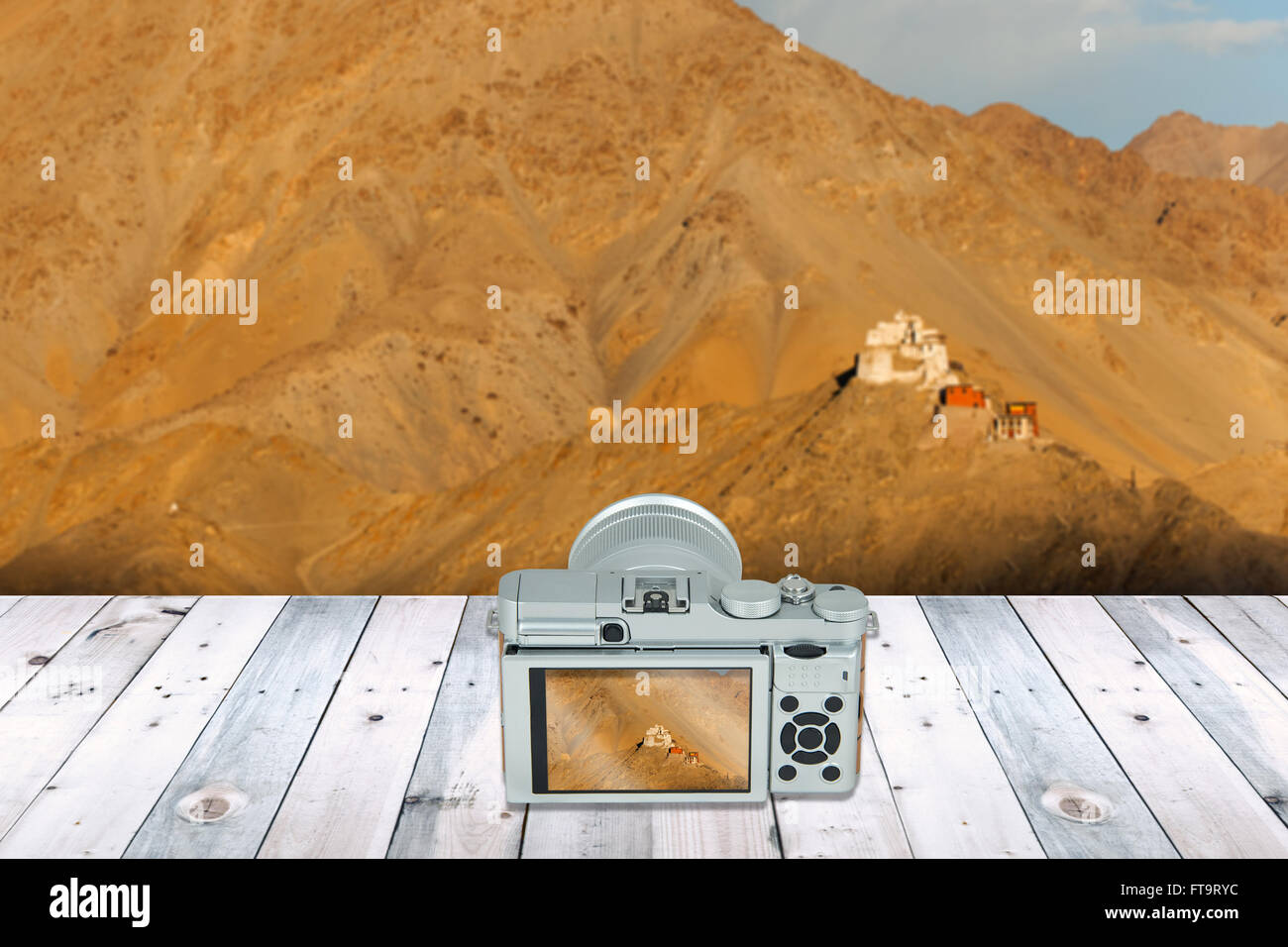 camera with screen display on wooden table with beautiful landscape in ...