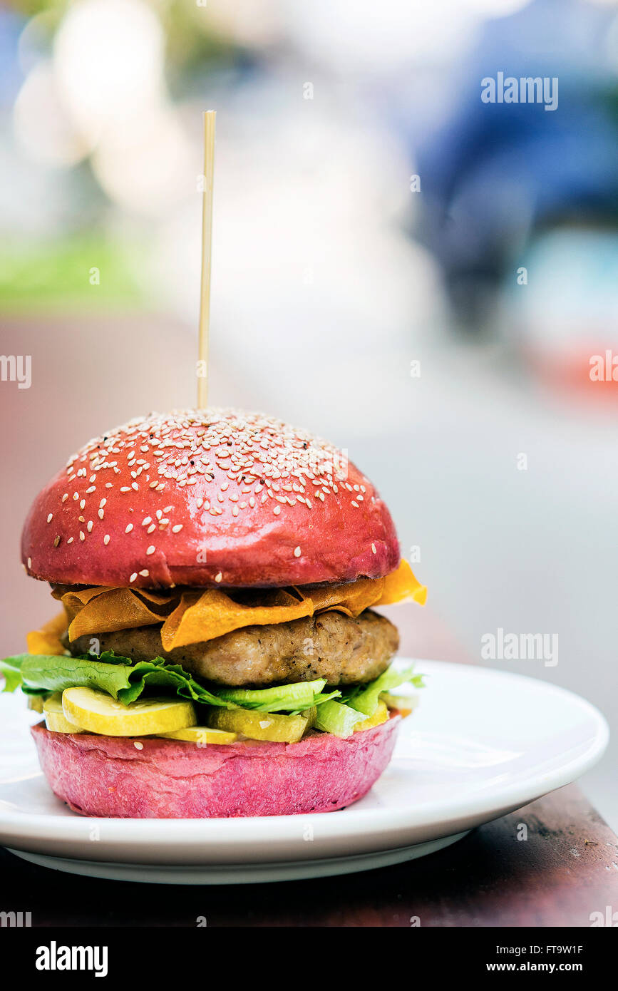 chicken burger with gherkins and crisps in beetroot bread bun Stock ...