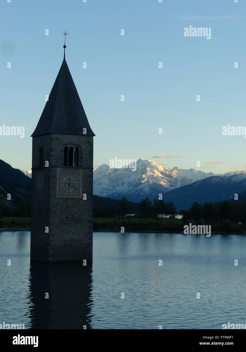 Partially submerged church and snow covered Alps in the background ...