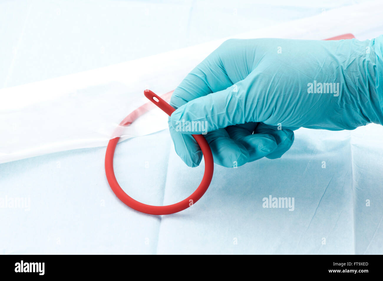 Nurse removes red rubber catheter from sterile package Stock Photo - Alamy