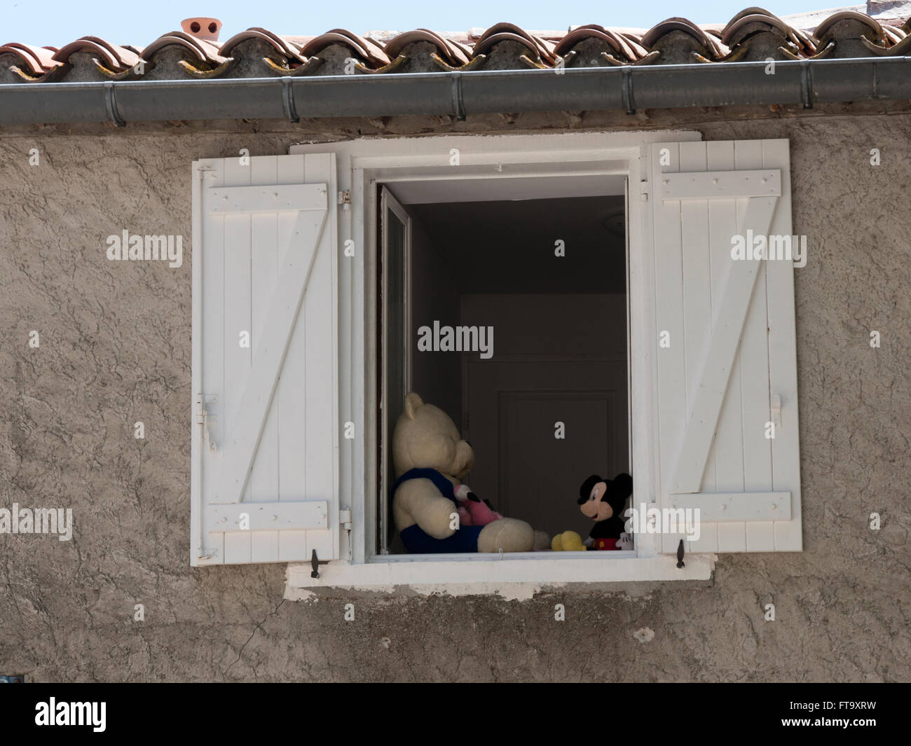 Soft toys, Micky Mouse and a large teddy bear inthe widow of a child's ...