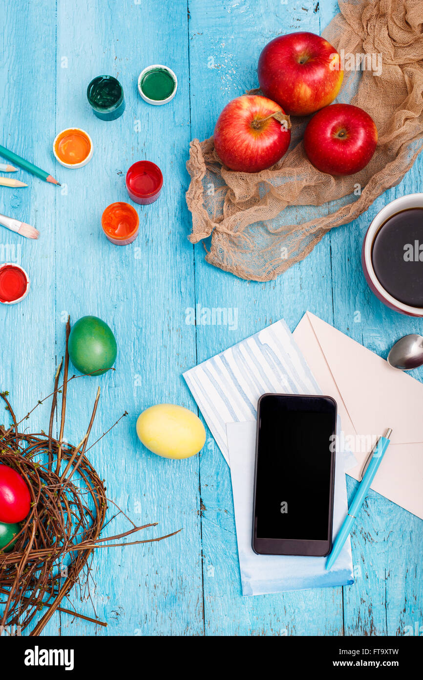 Easter in the office workplace on blue wooden table. Top view with ...