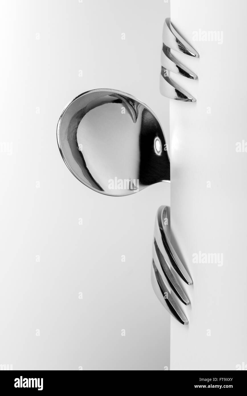 Spoon and two forks formed into conceptual figure Stock Photo - Alamy