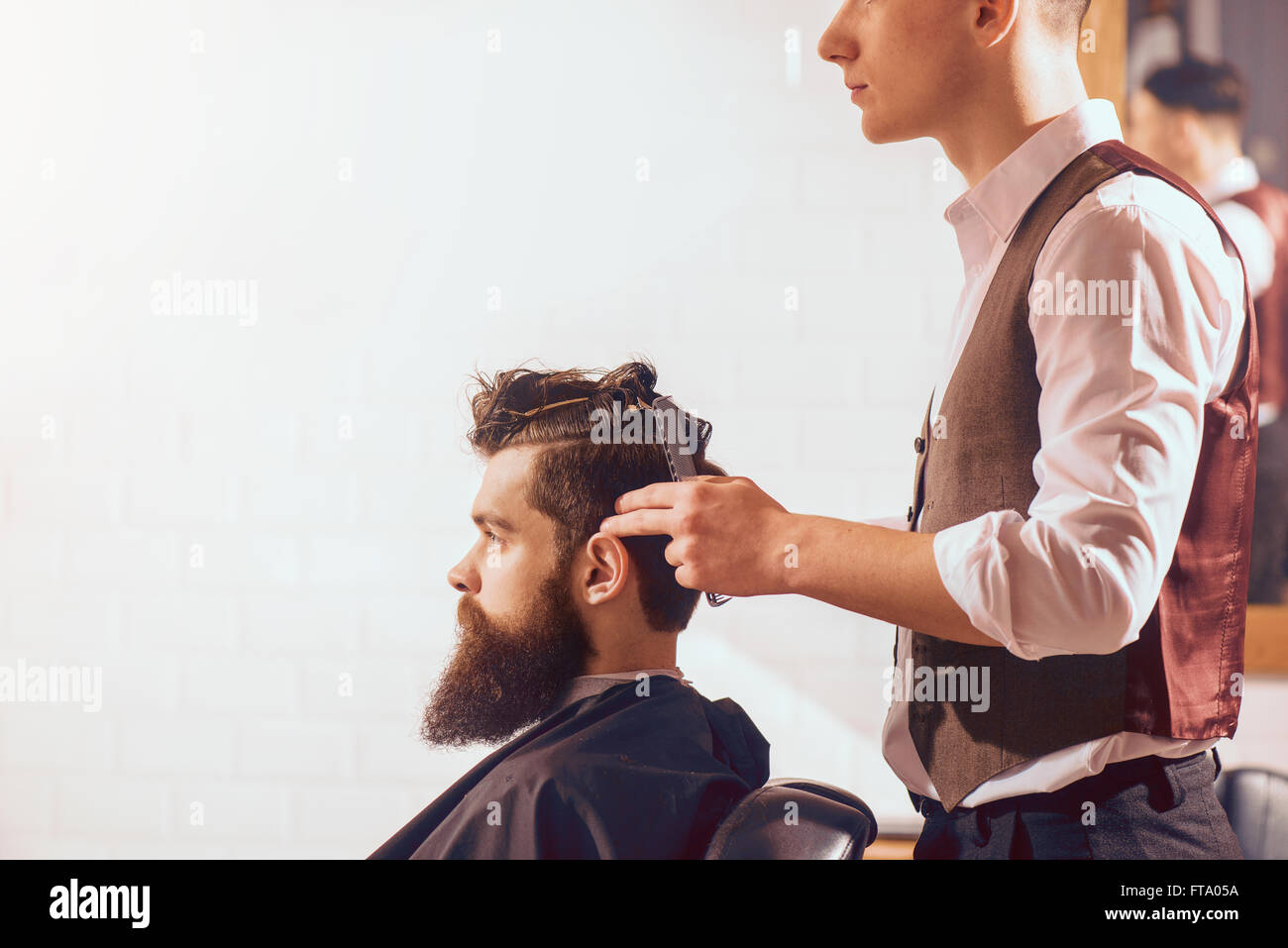 Professional barber styling hair of his client Stock Photo - Alamy