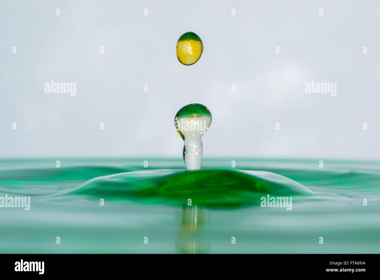 a drop of water falls and creates a splash Stock Photo - Alamy