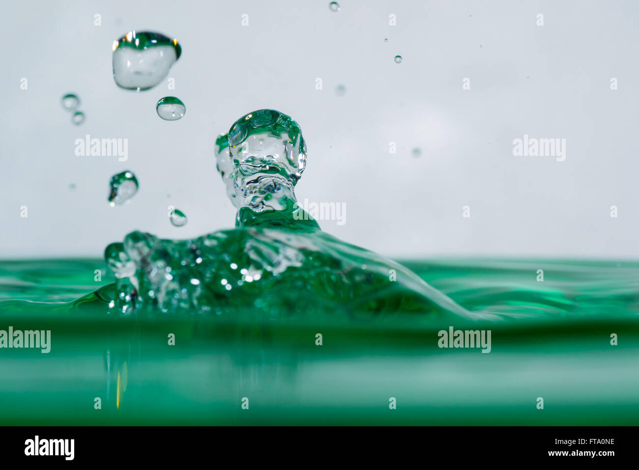 a drop of water falls and creates a splash Stock Photo - Alamy