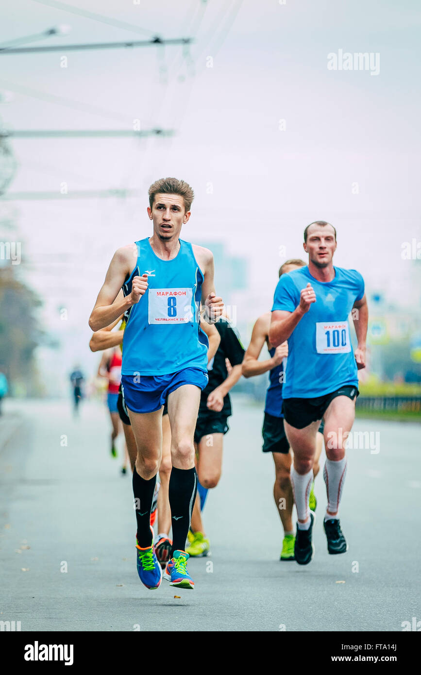 group of runners running down a city street during Chelyabinsk marathon ...