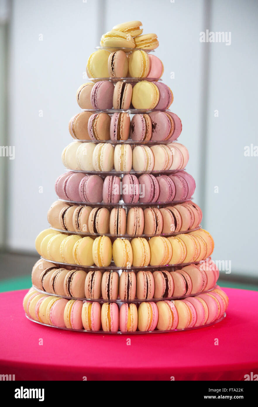 Colorful macarons on pyramid-shaped plastic stand on many visible ...