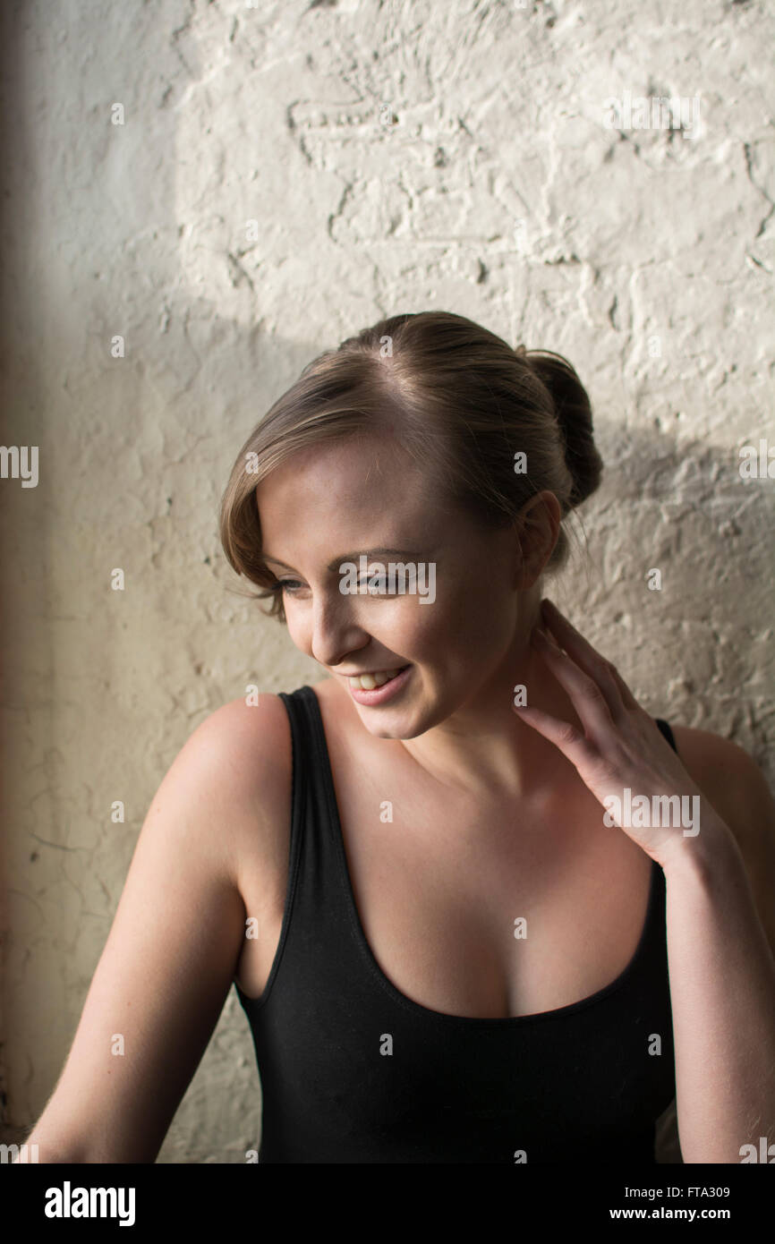 Happy beautiful young woman hand touching neck looking away smiling ...