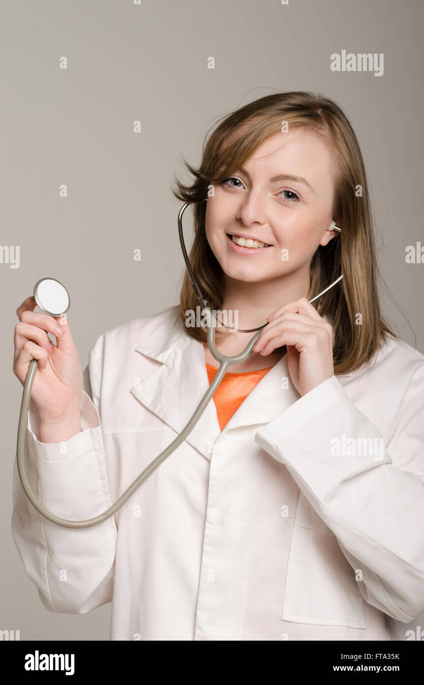Happy female doctor holding a stethoscope smiling Stock Photo - Alamy