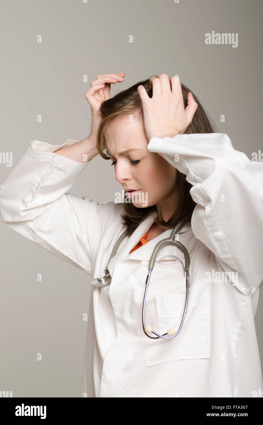 Frustrated female doctor head in hands Stock Photo - Alamy