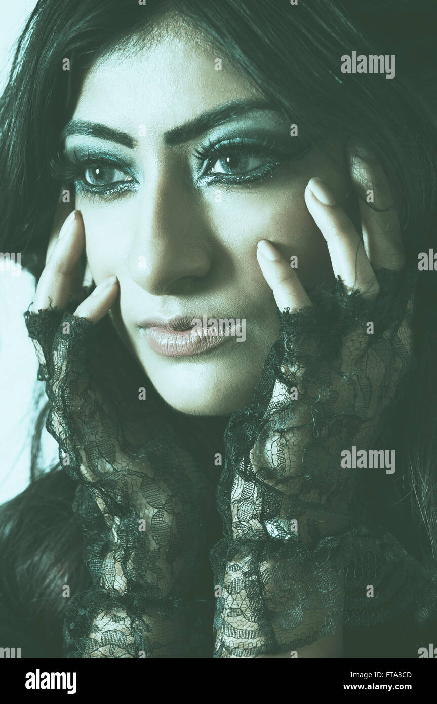 Woman wearing lacy gloves hands touching face looking away Stock Photo ...