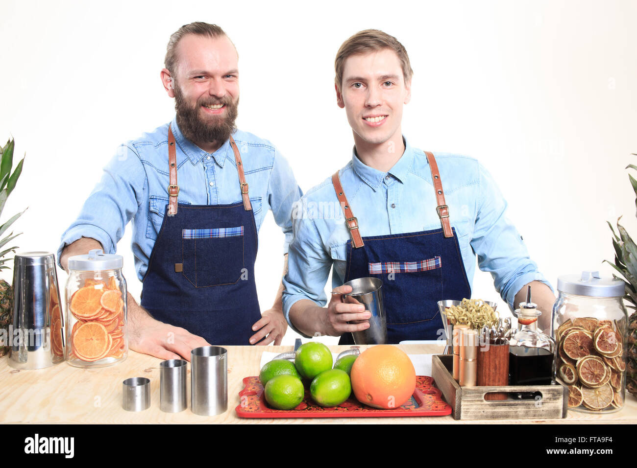 two bartender with a shaker and bottle on white background. behind the ...
