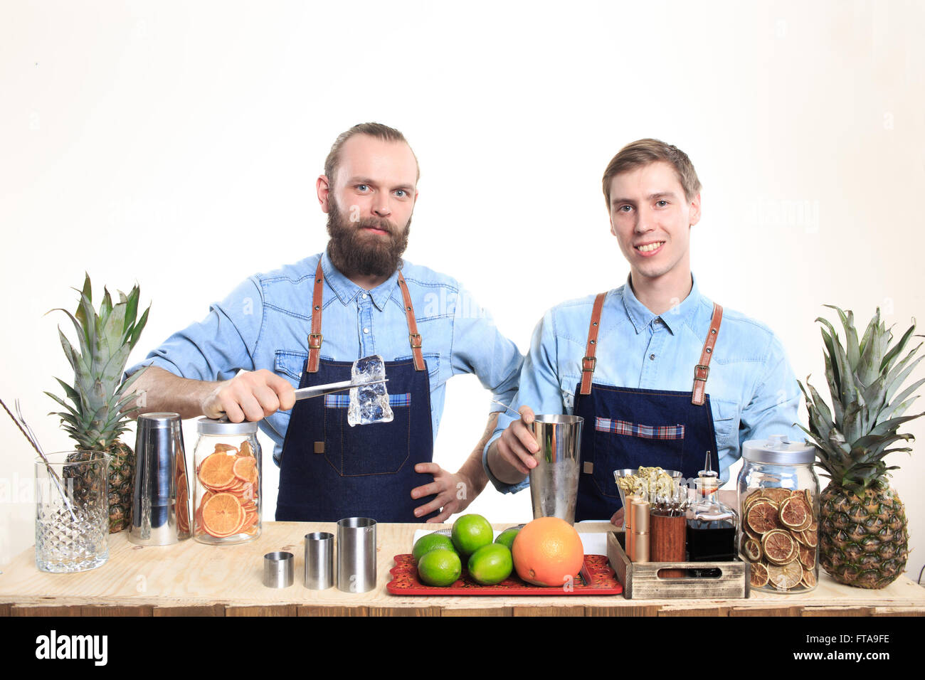 two bartender with a shaker and bottle on white background. behind the ...