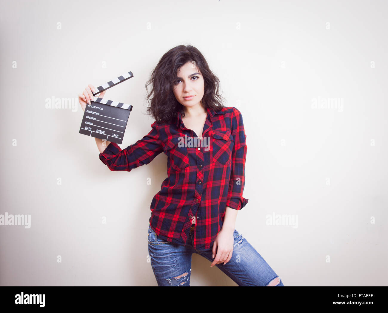 Young woman in red shirt showing movie clapper board on white ...