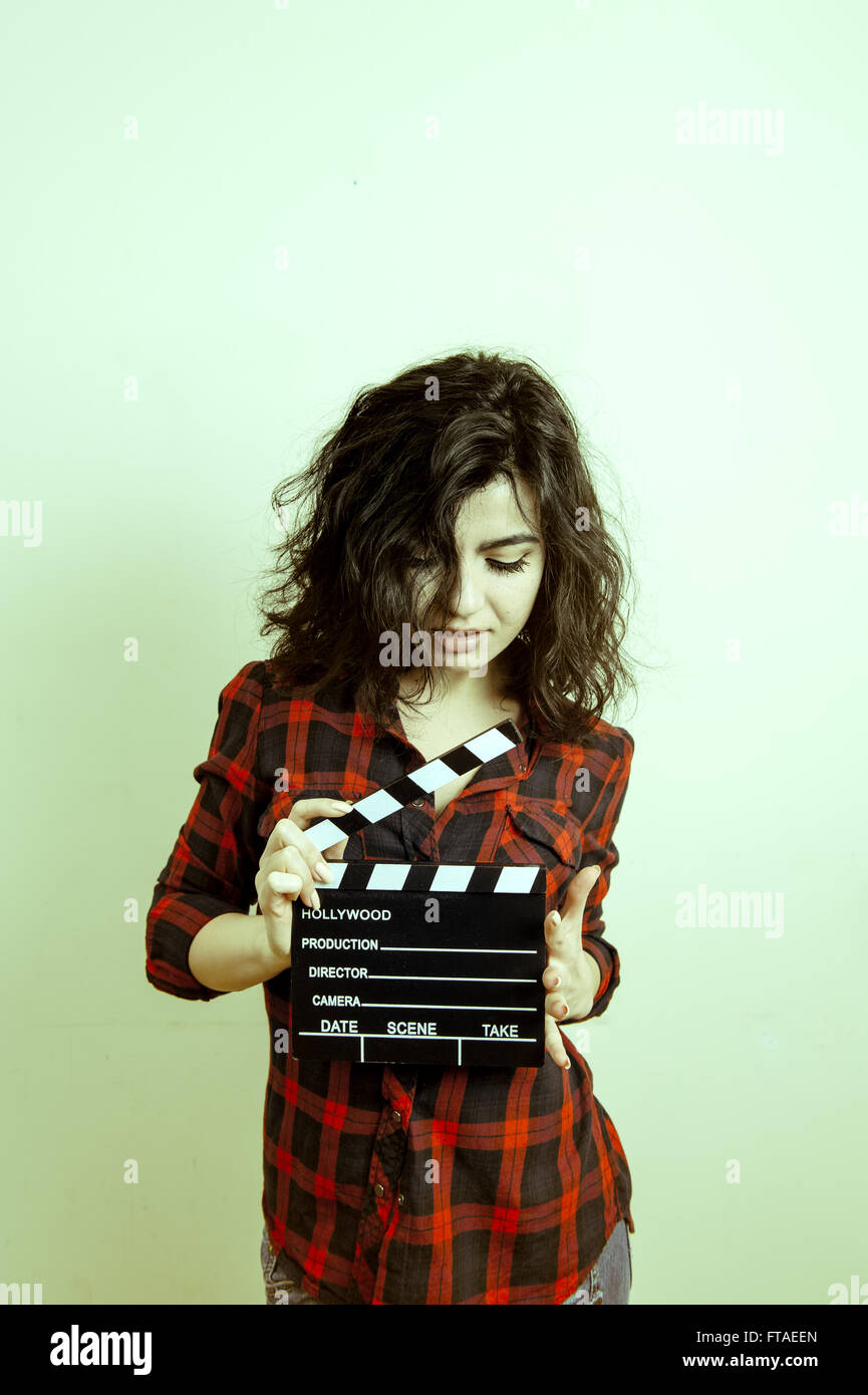 Young woman in red shirt showing movie clapper board vintage color ...