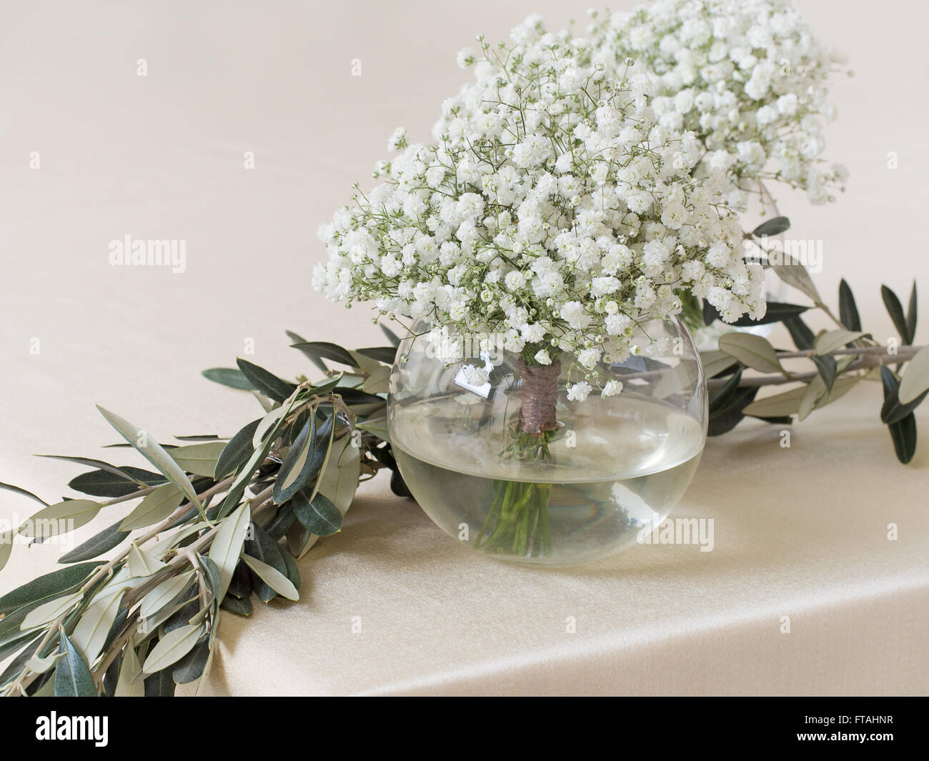 White flowers and olive leaves on table Stock Photo - Alamy