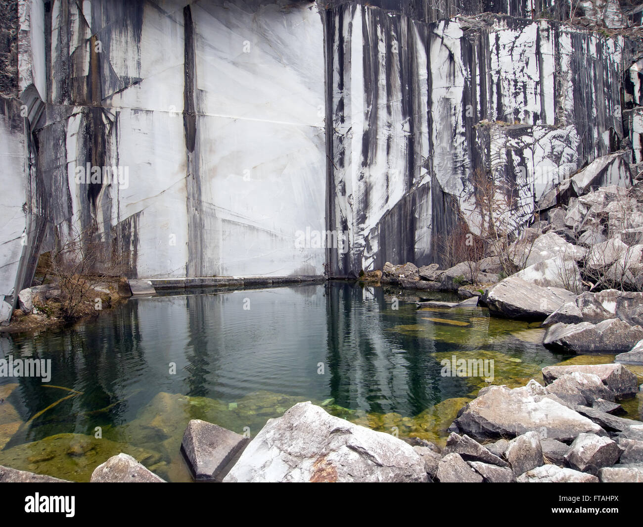 Natural pool in old,abandoned marble quarry. Reclaimed by nature. With ...
