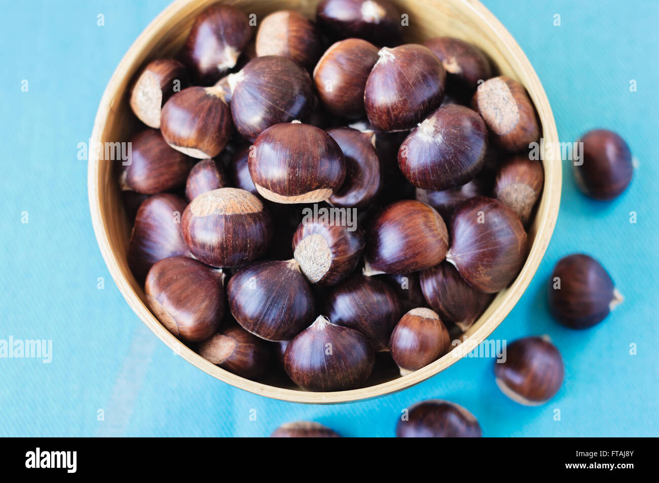 Bamboo bowl of fresh chestnuts on a blue background Stock Photo - Alamy