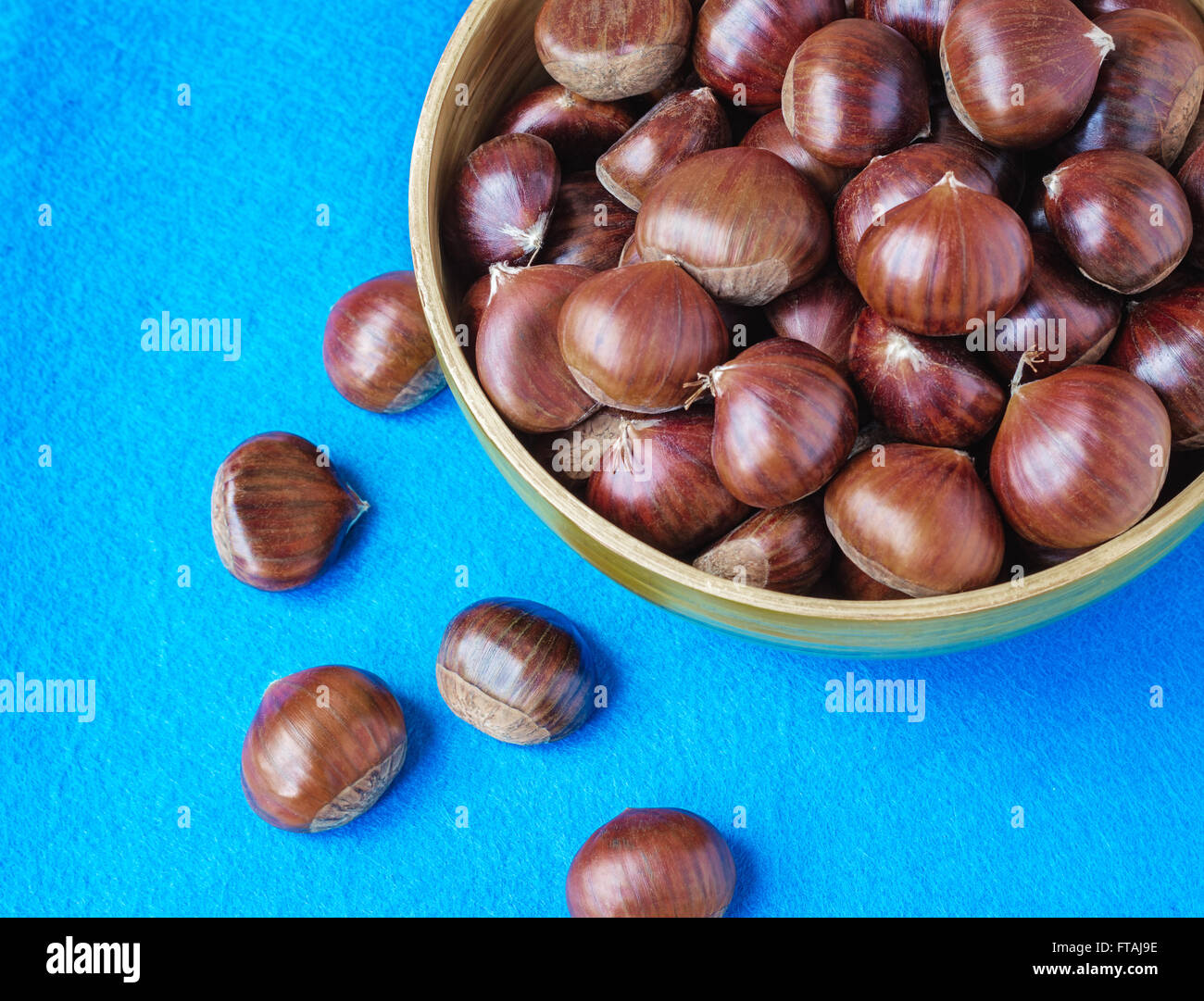 Bamboo bowl of fresh chestnuts on a blue background Stock Photo - Alamy