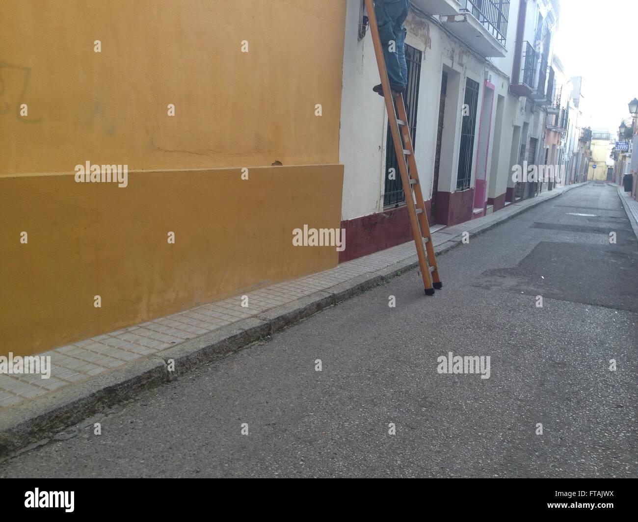 electrician fixing street light wires and climbing on a ladder, old ...
