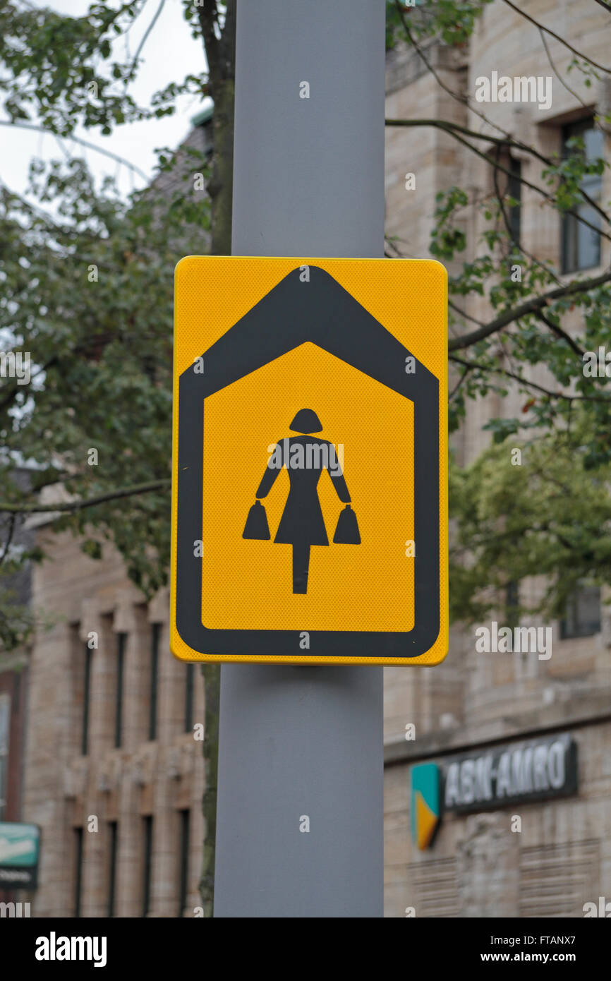 Pedestrian sign showing a woman carrying bags in The Hague, Netherlands ...