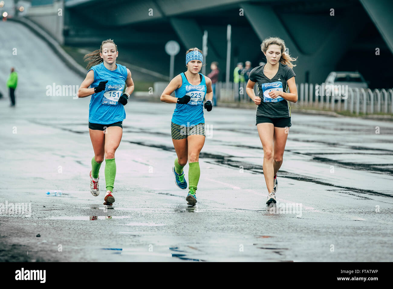 Omsk, Russia - September 20, 2015: three girls runners run on wet ...