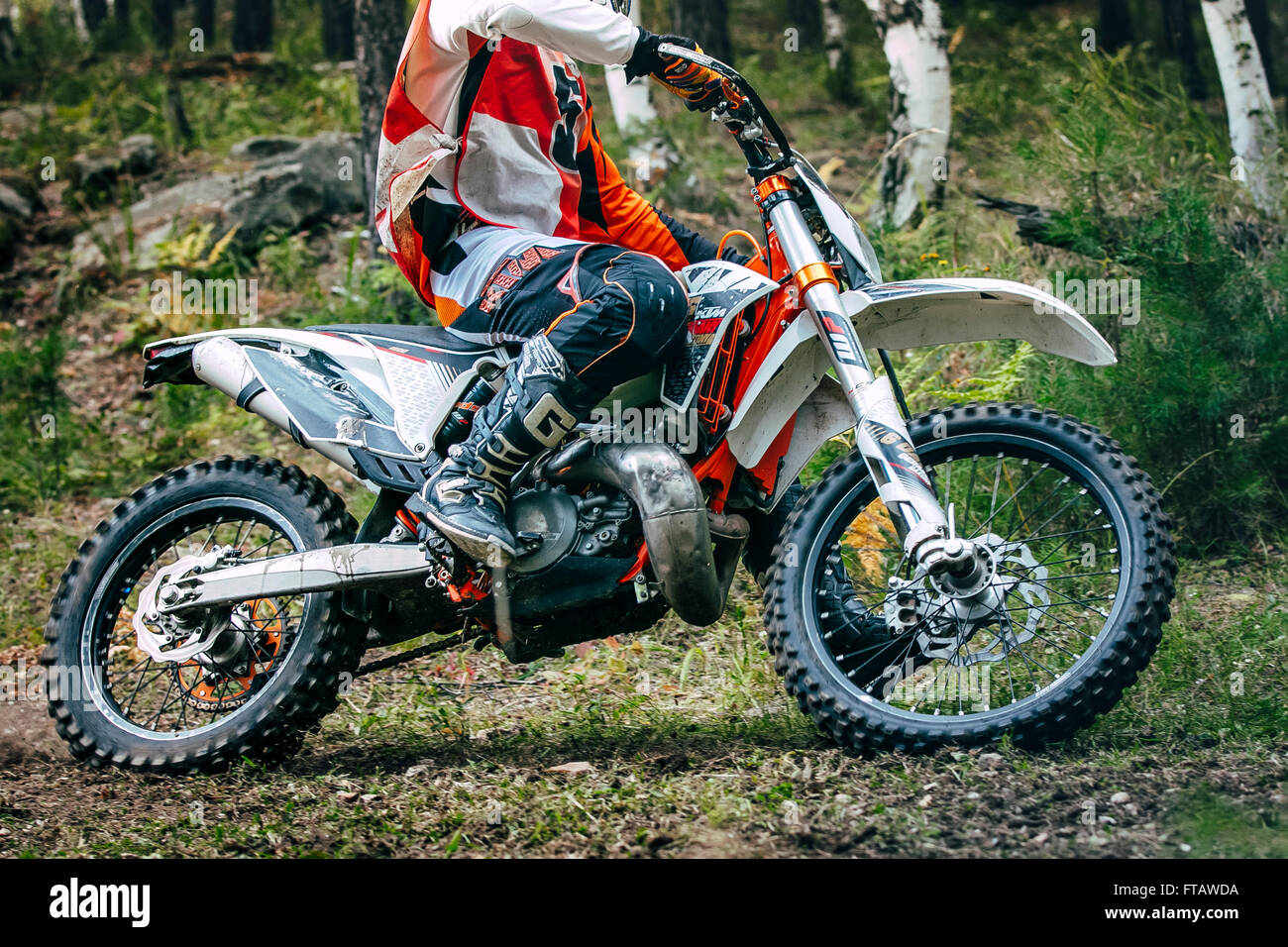 Enduro racer is riding through woods during "Urals Cup of Enduro Stock ...