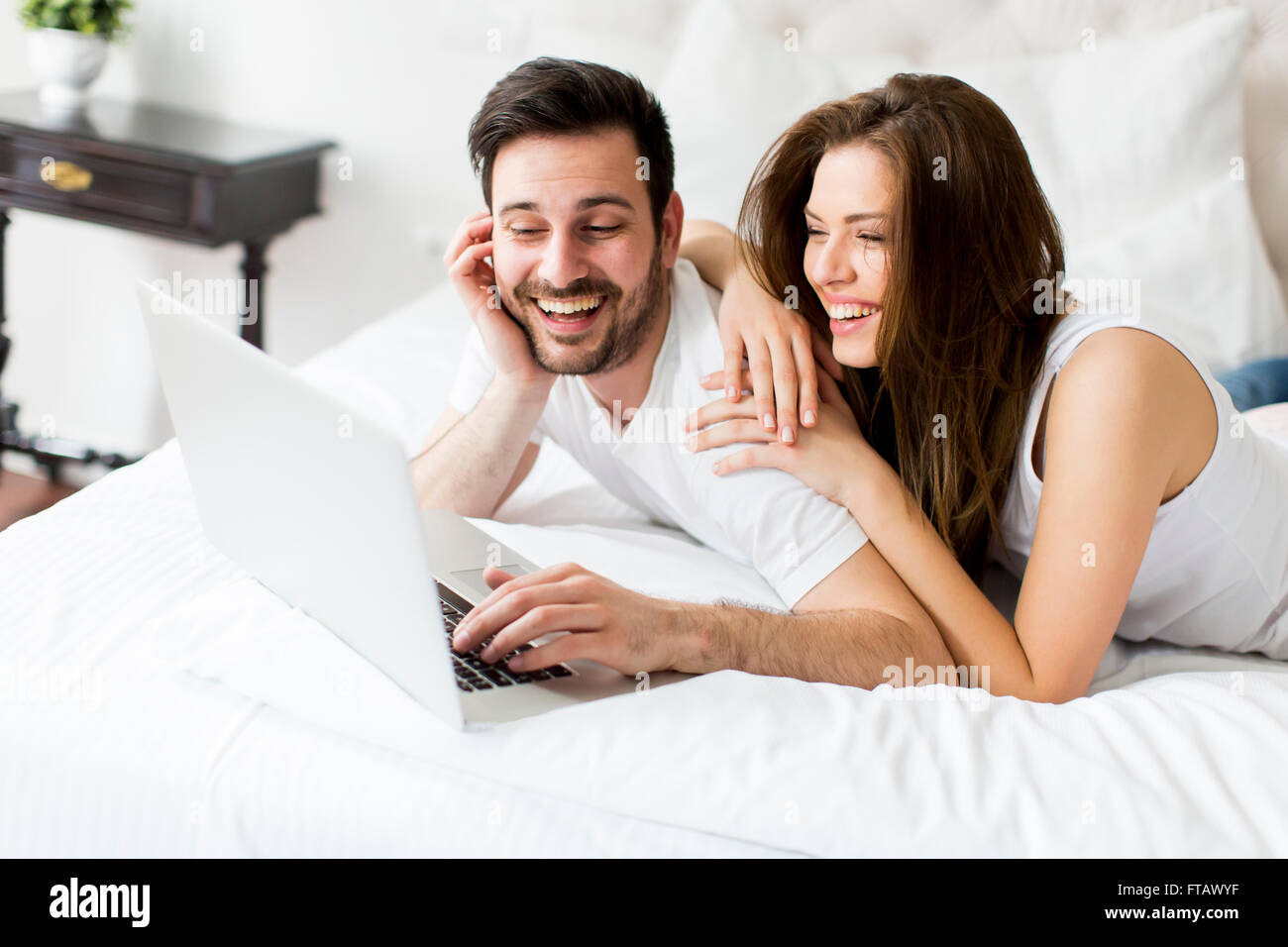 Young couple with laptop in the bed Stock Photo - Alamy