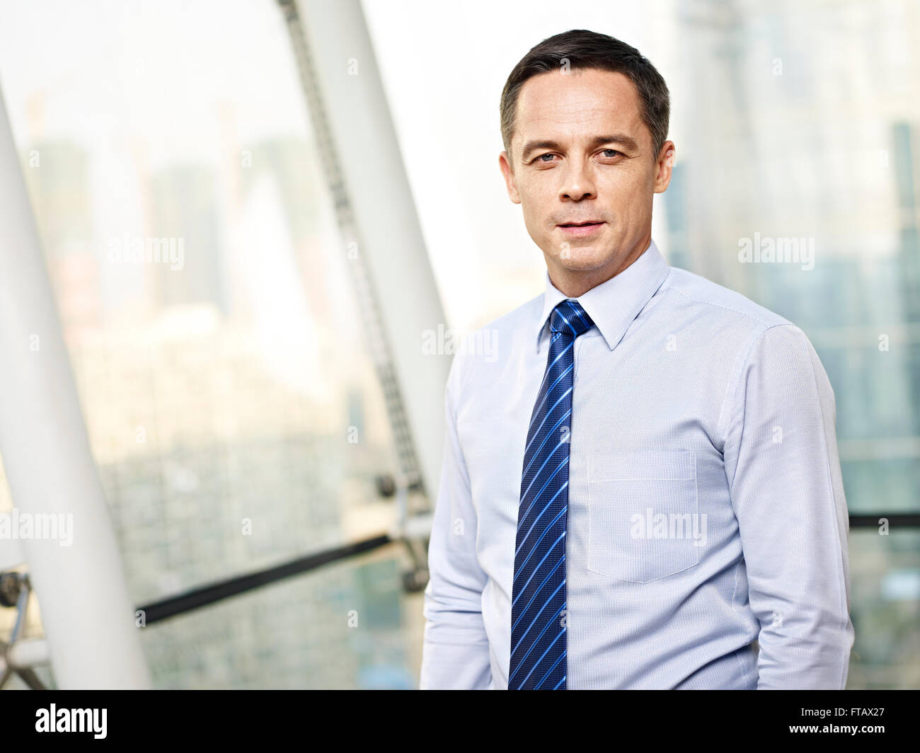 portrait of a business executive standing by the window in office Stock ...