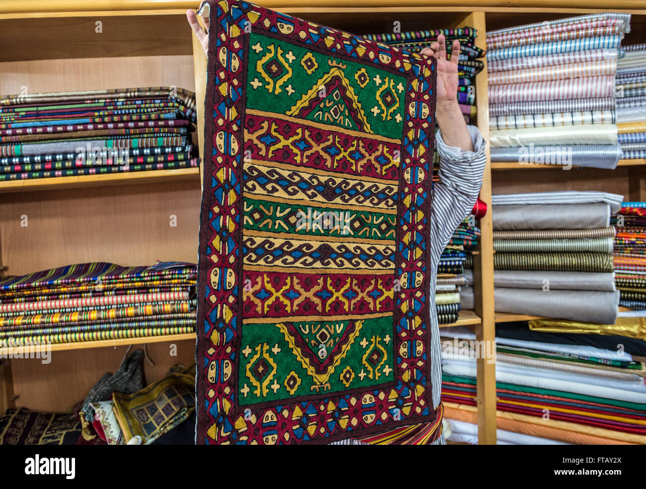 Bilal Abu Khalaf, dealer of imported orient fabrics, shows small carpet ...