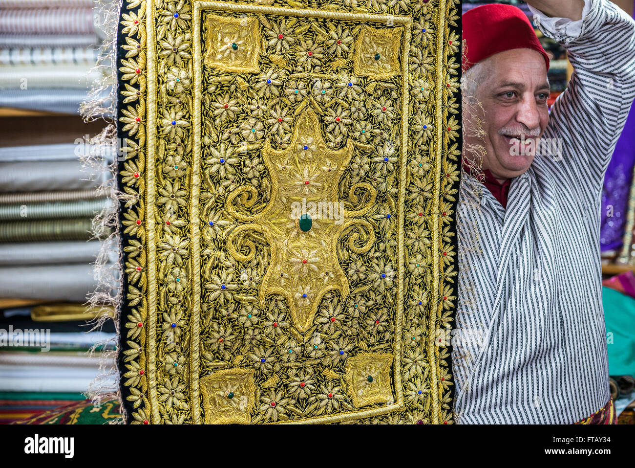 Bilal Abu Khalaf, dealer of imported orient fabrics, shows small carpet ...