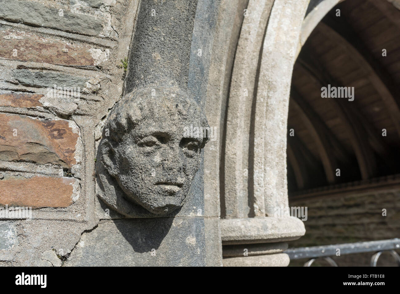 Stone carving of the head of a man, at the porch of St Gwynno's Church ...